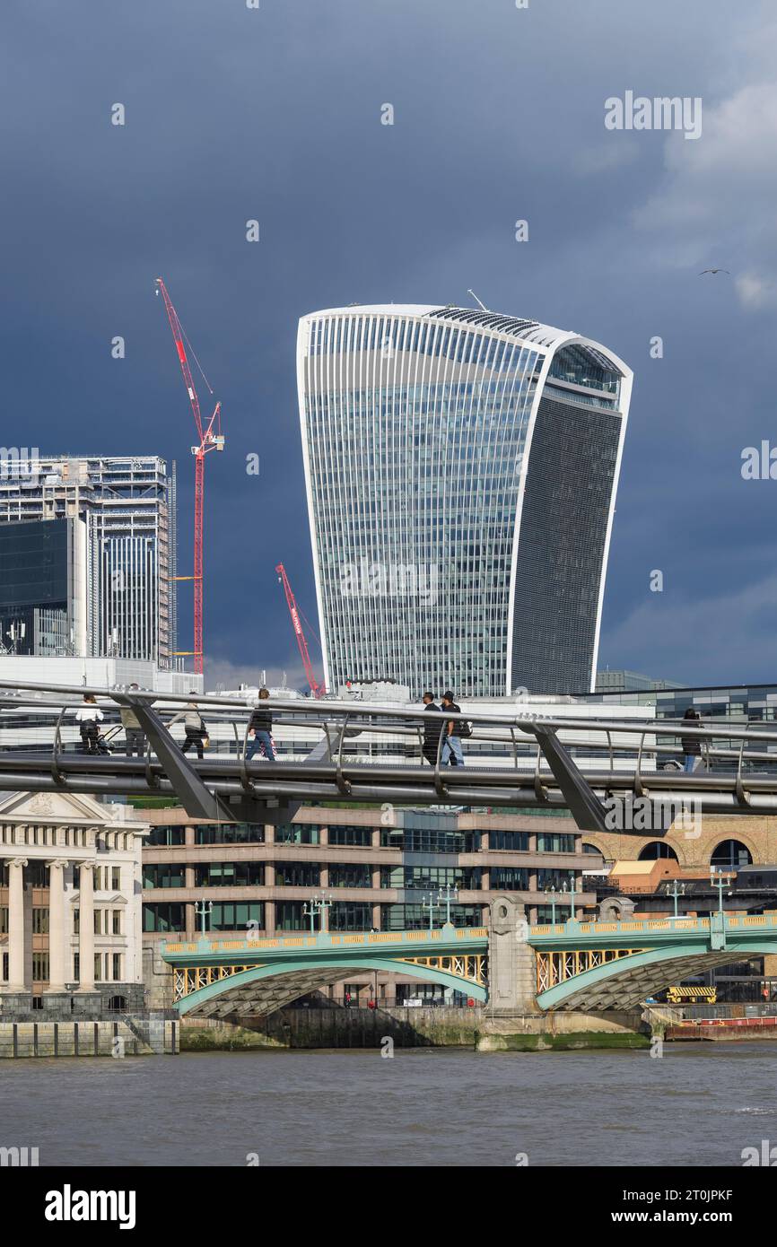 The Millennium footbridge over the River Thames with the Skysrapers of ...
