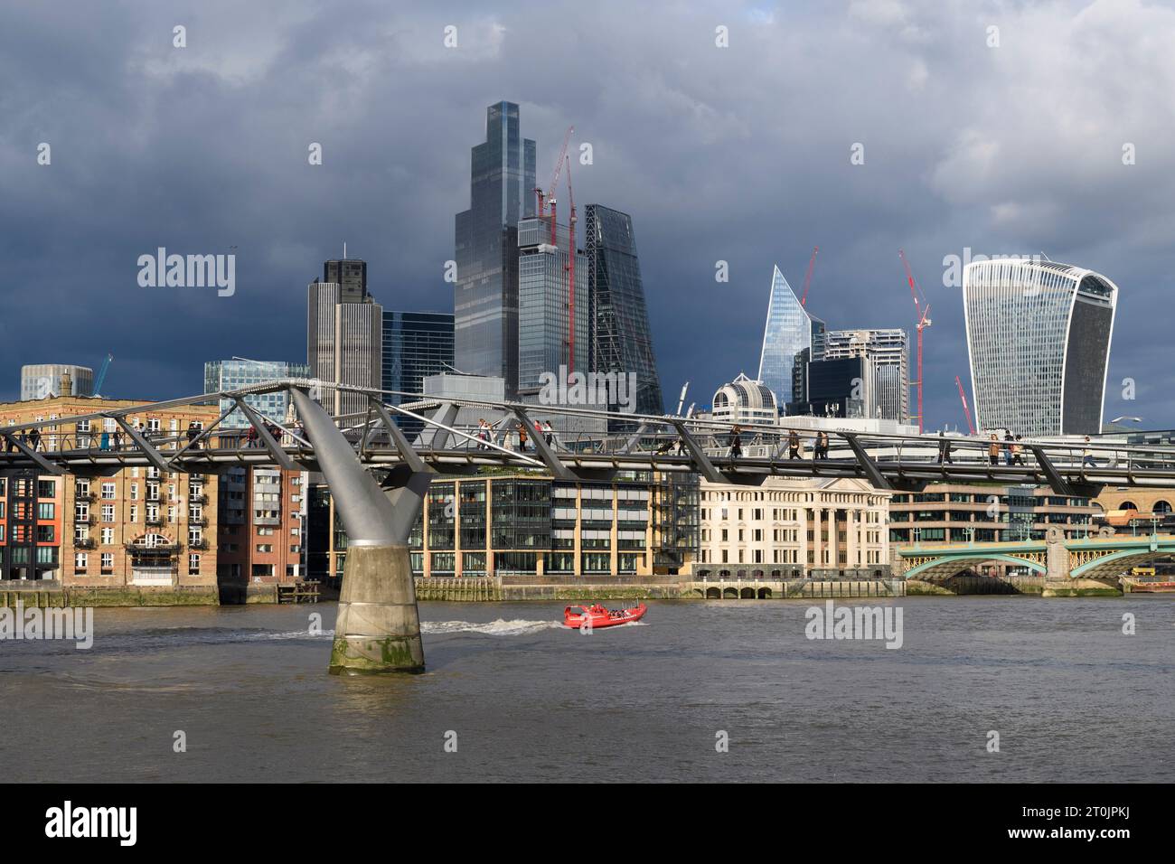 The Millennium footbridge over the River Thames with the Skysrapers of ...
