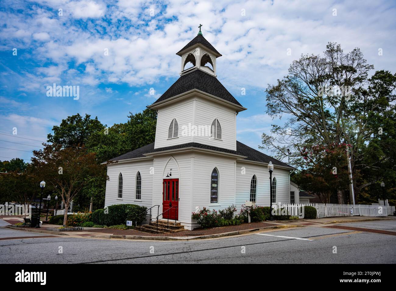 A charming house of worship with arched windows and inviting red doors ...