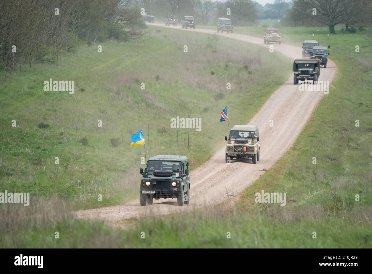 a convoy of old military vehicles, Ukrainian flag on first Land Rover ...