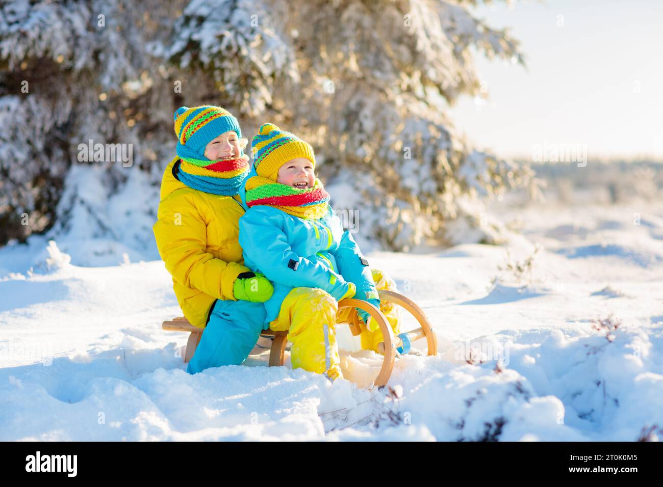 Little girl and boy enjoying sleigh ride. Child sledding. Toddler kid ...