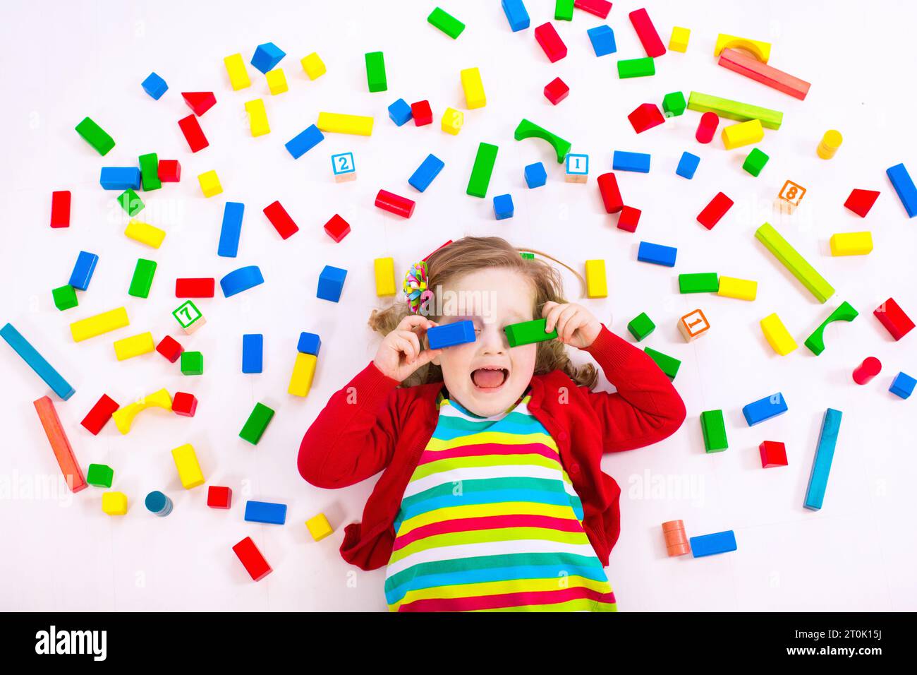 Child playing with colorful wooden toys. Little girl with educational ...