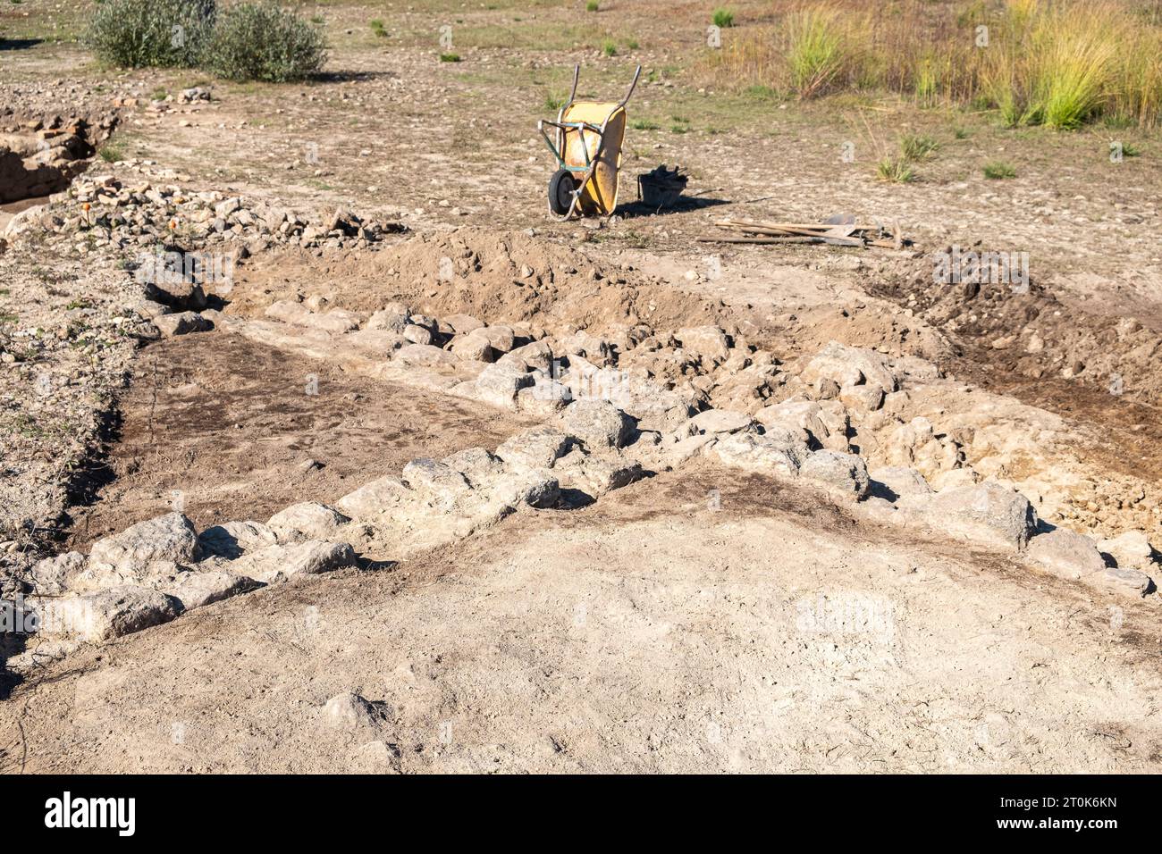 wheelbarrow next to some Roman walls discovered in an archaeological ...