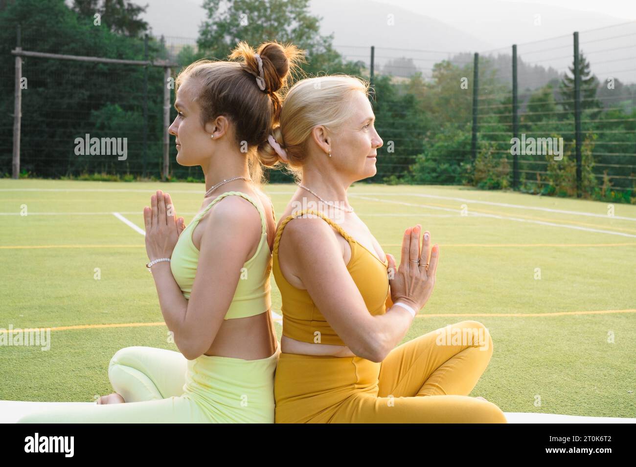 Two woman doing yoga outdoors Mother and adult daughter practicing ...