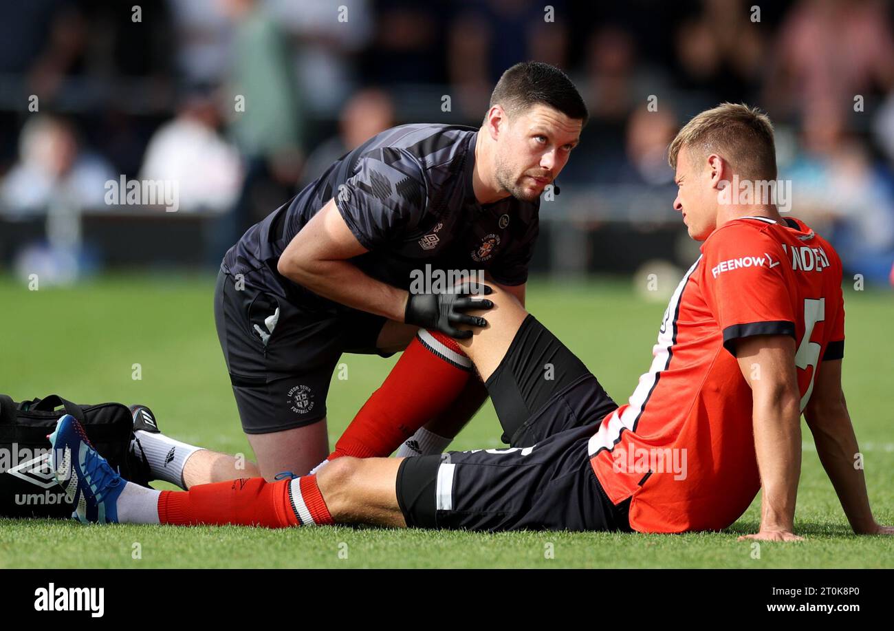 Luton Town's Mads Juel Andersen receives medical treatment during the ...