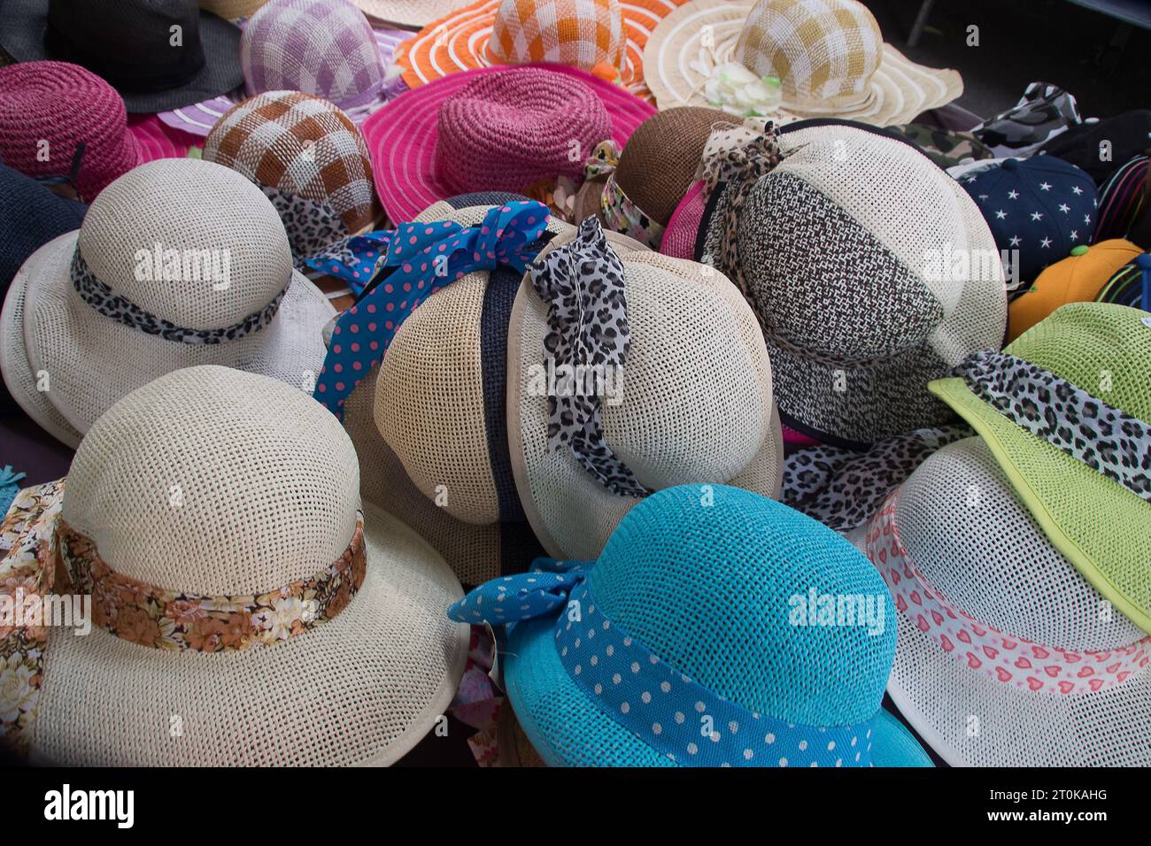 A selection of vibrant patterned hats with decorative bows arranged in ...
