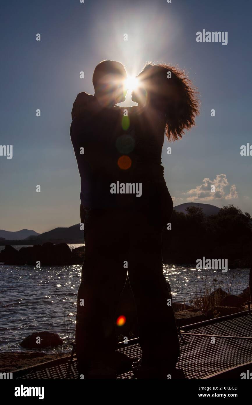 silhouettes rim light at sunset sun rays couple in love on a bridge at ...