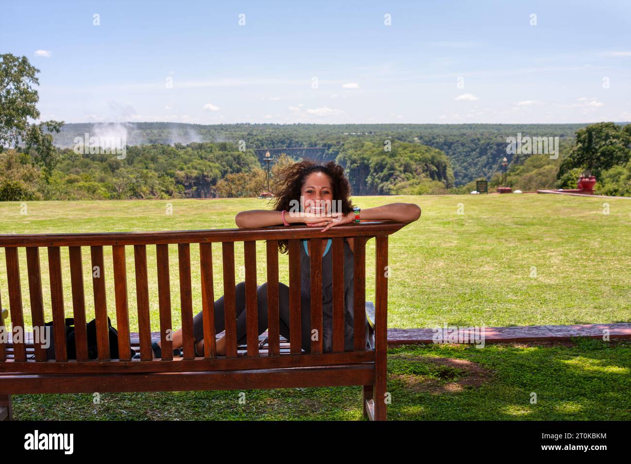 Victoria Falls in Zimbabwe, holiday woman on siting on a wooden bench ...