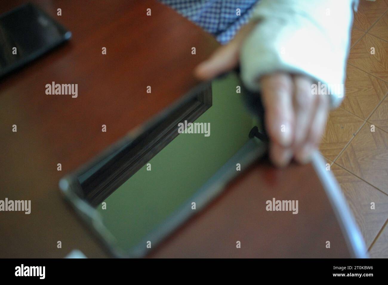 old woman with a cast in her wrist is grabbing a mobile phone Stock ...