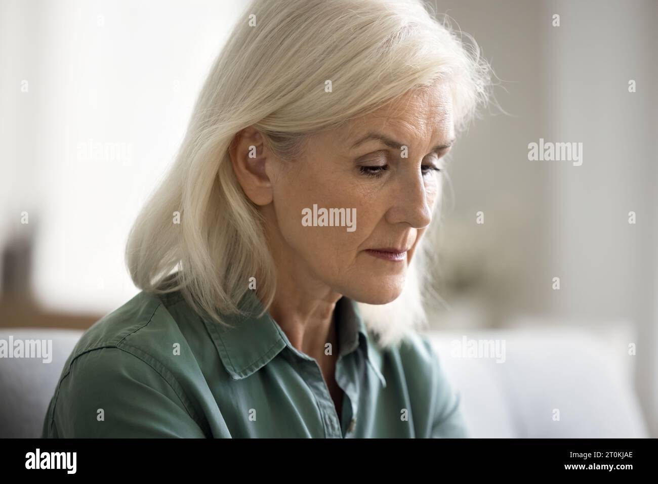 Sad lost blonde elderly lady staring into vacancy Stock Photo - Alamy