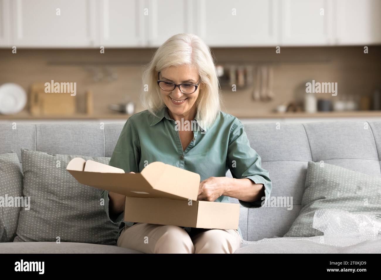 Senior woman opening parcel box hi-res stock photography and images - Alamy