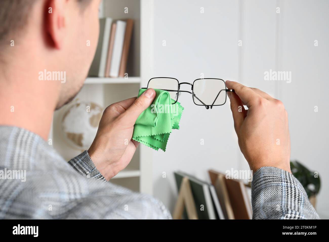 Man wiping glasses with microfiber cloth indoors Stock Photo - Alamy