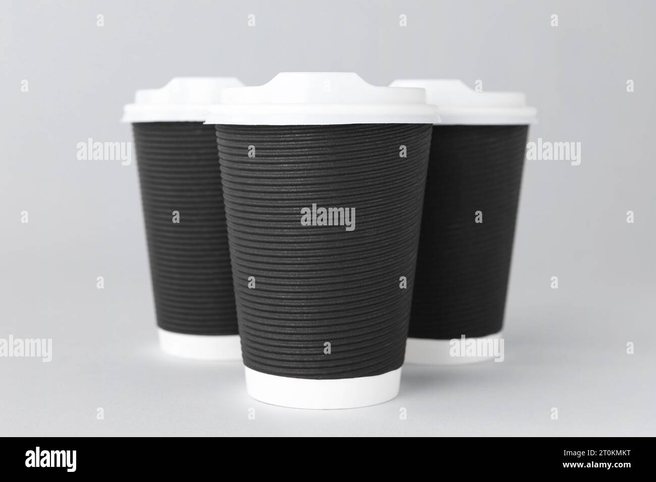 Paper cups with white lids on light grey background. Coffee to go Stock ...