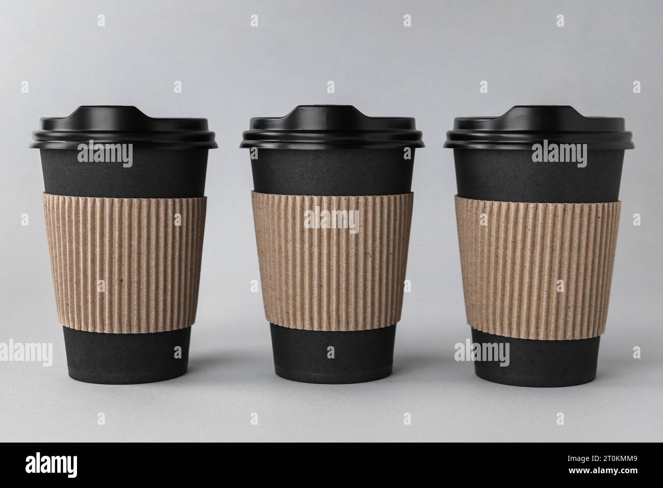Paper cups with black lids on light grey background. Coffee to go Stock ...