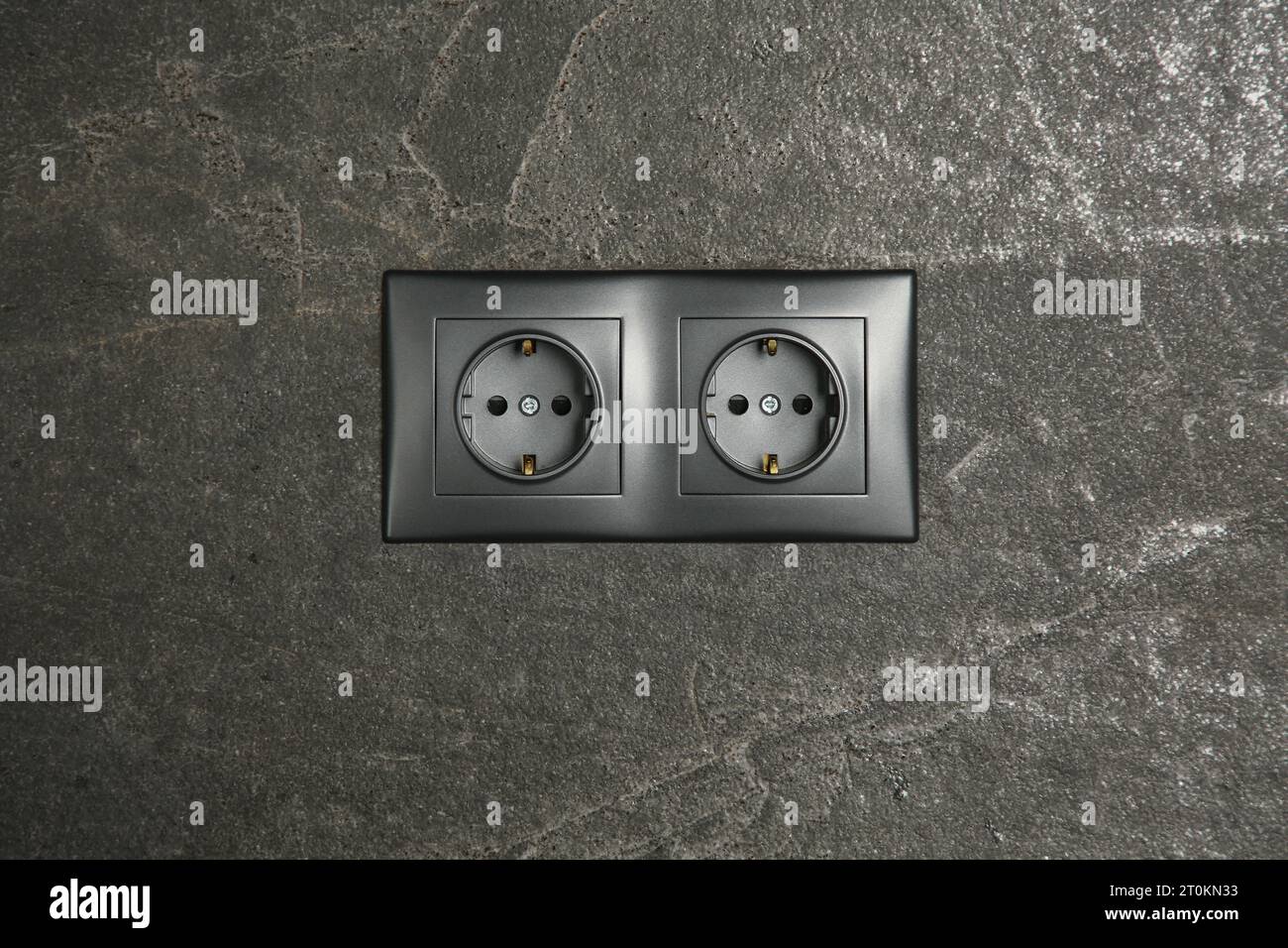 Power sockets on dark grey wall. Electrical supply Stock Photo - Alamy