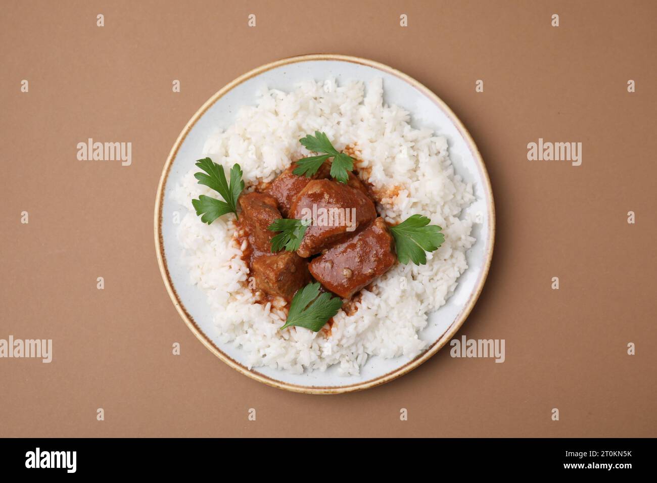 Delicious goulash with rice on brown background, top view Stock Photo ...