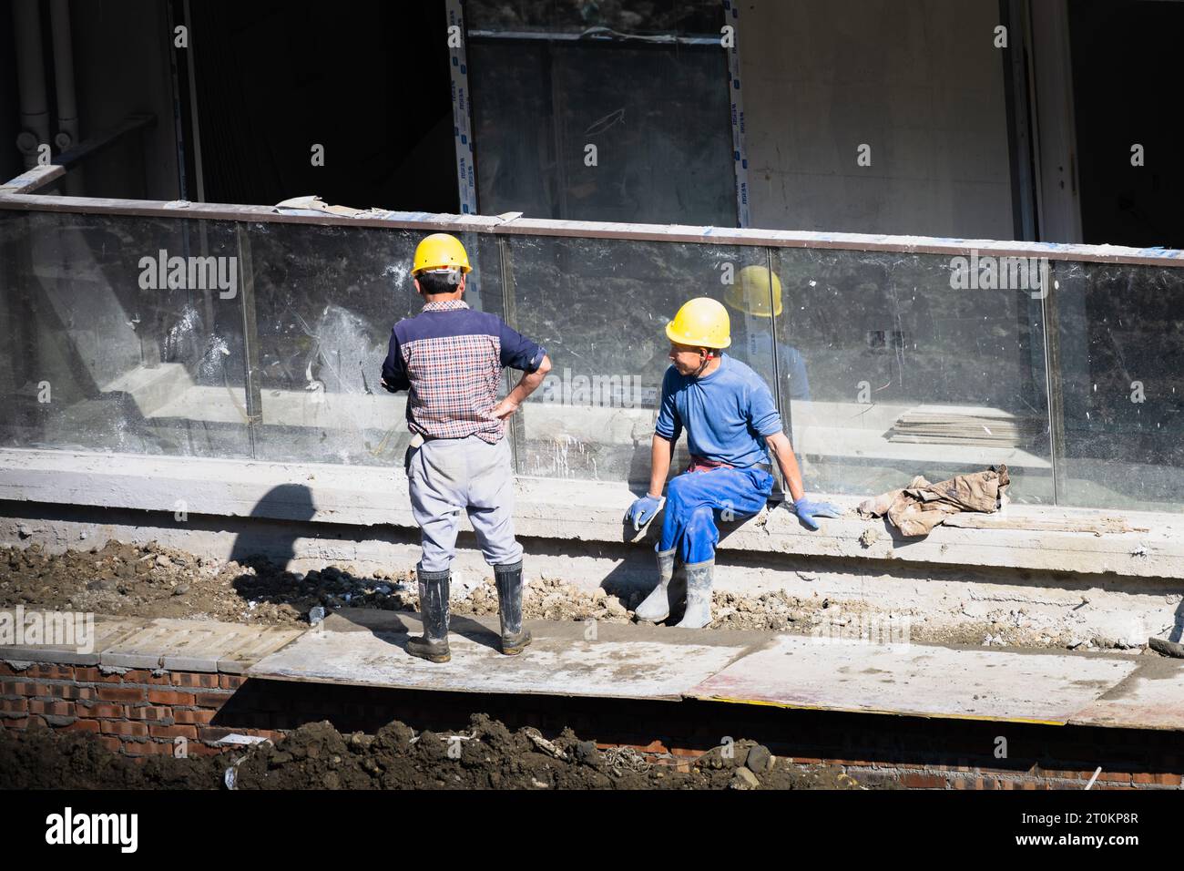 On a sunny day, construction workers are taking a break next to the ...