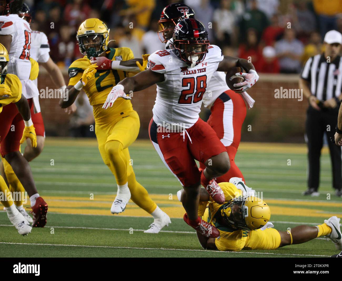 Texas Tech running back Tahj Brooks (28) slips past Baylor linebacker ...