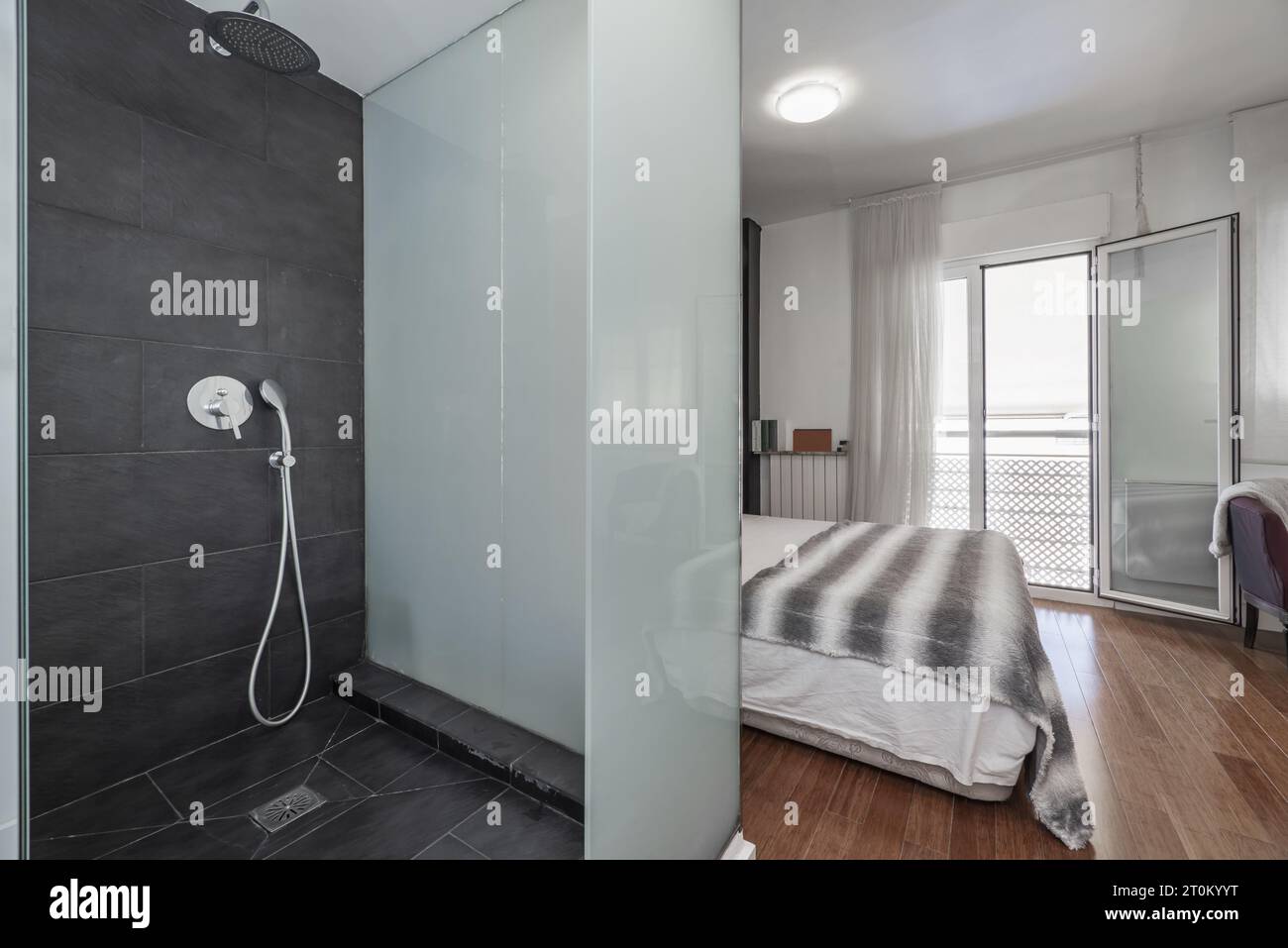 Bathroom with shower cabin with tempered glass next to an en-suite ...