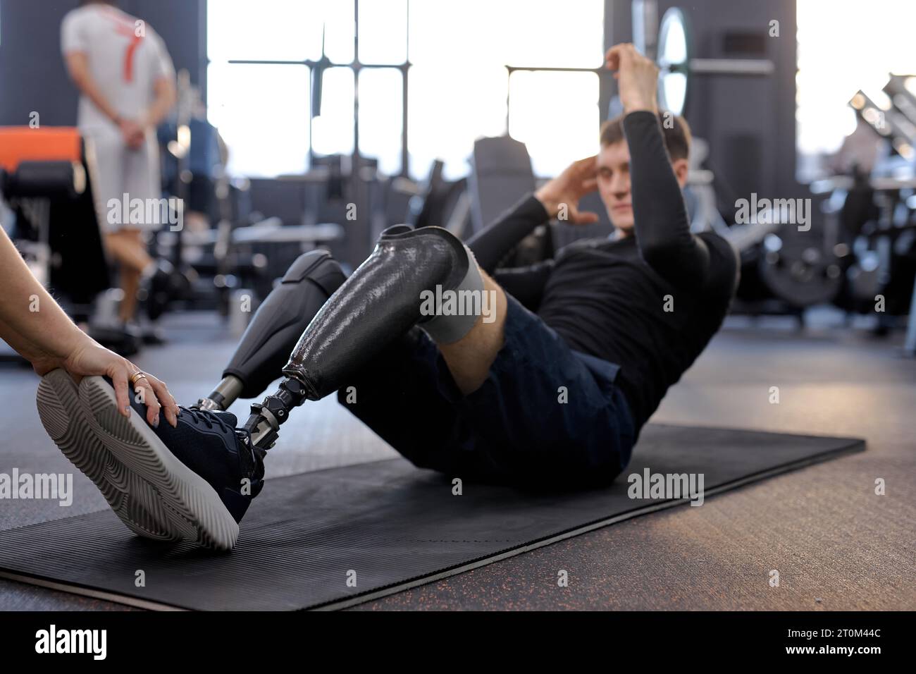 motivated strong man with legs prosthesis doing abdominal crunches ...