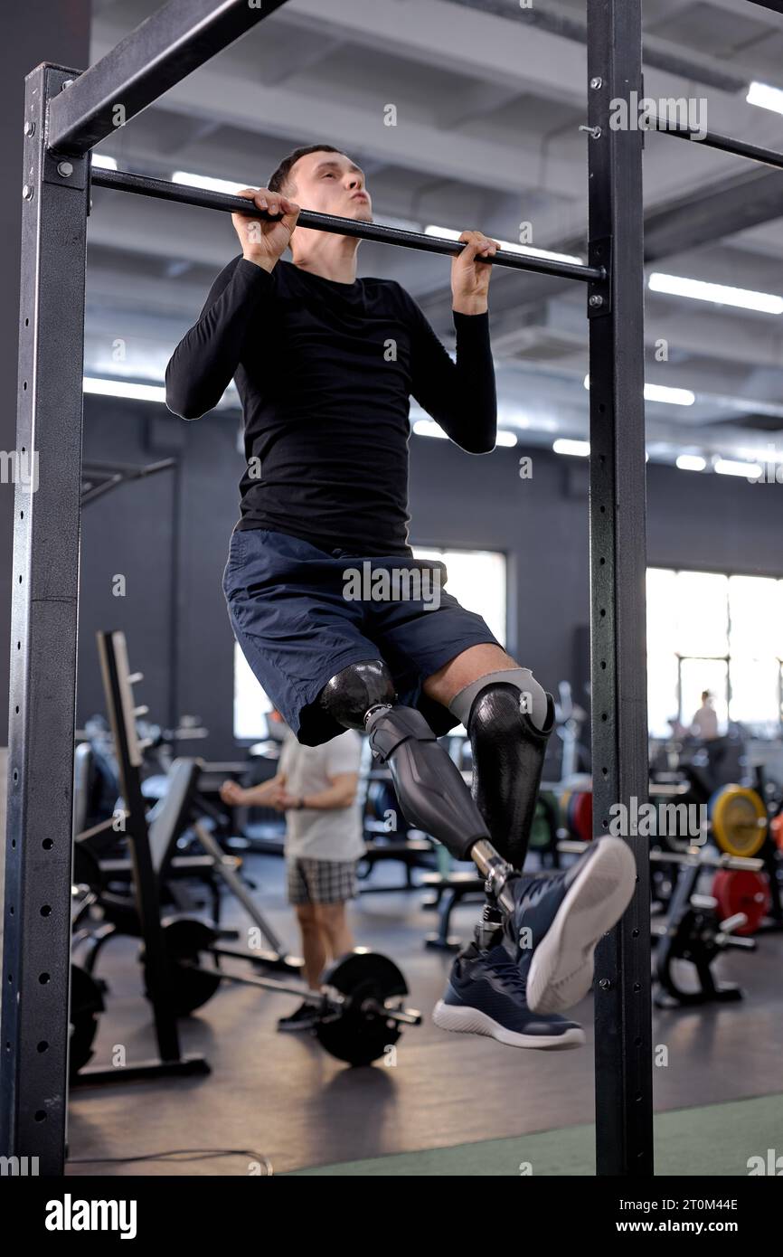 active ambitious man with prosthetic leg wearing sports clothing doing ...