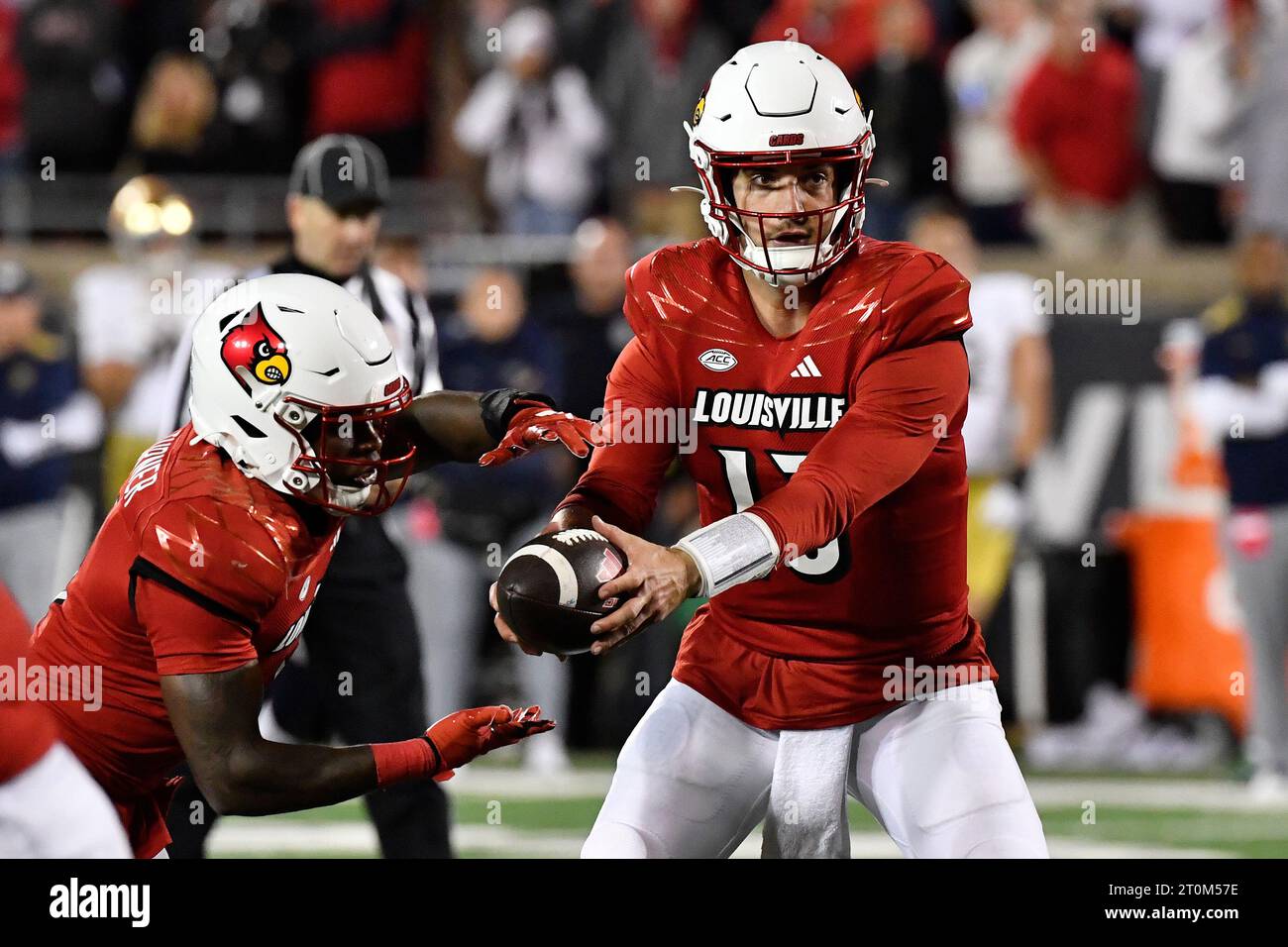 Louisville quarterback Jack Plummer (13) hands the ball off to running ...