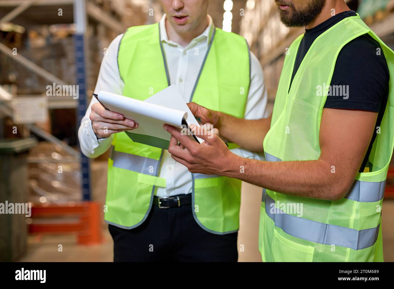 Caucasian two engineers in uniform, checking goods and supplies on ...