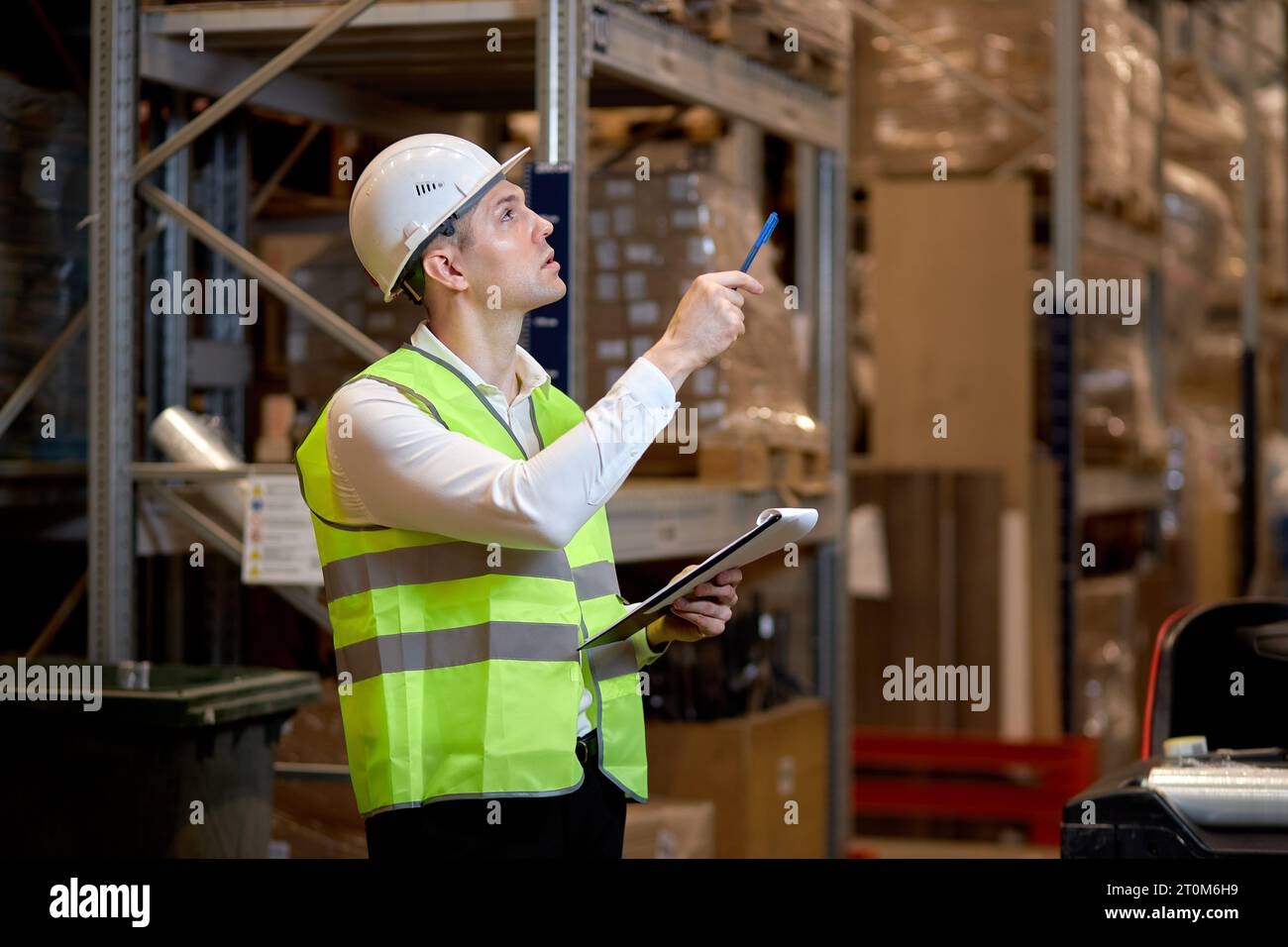 male worker doing stocktaking of product management on shelves in ...
