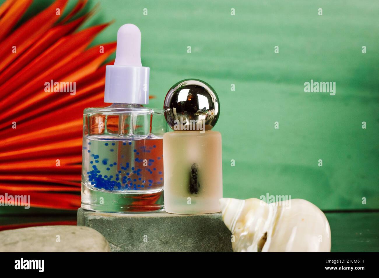Makeup product, seashell on emerald background. Essential cuticle oil ...