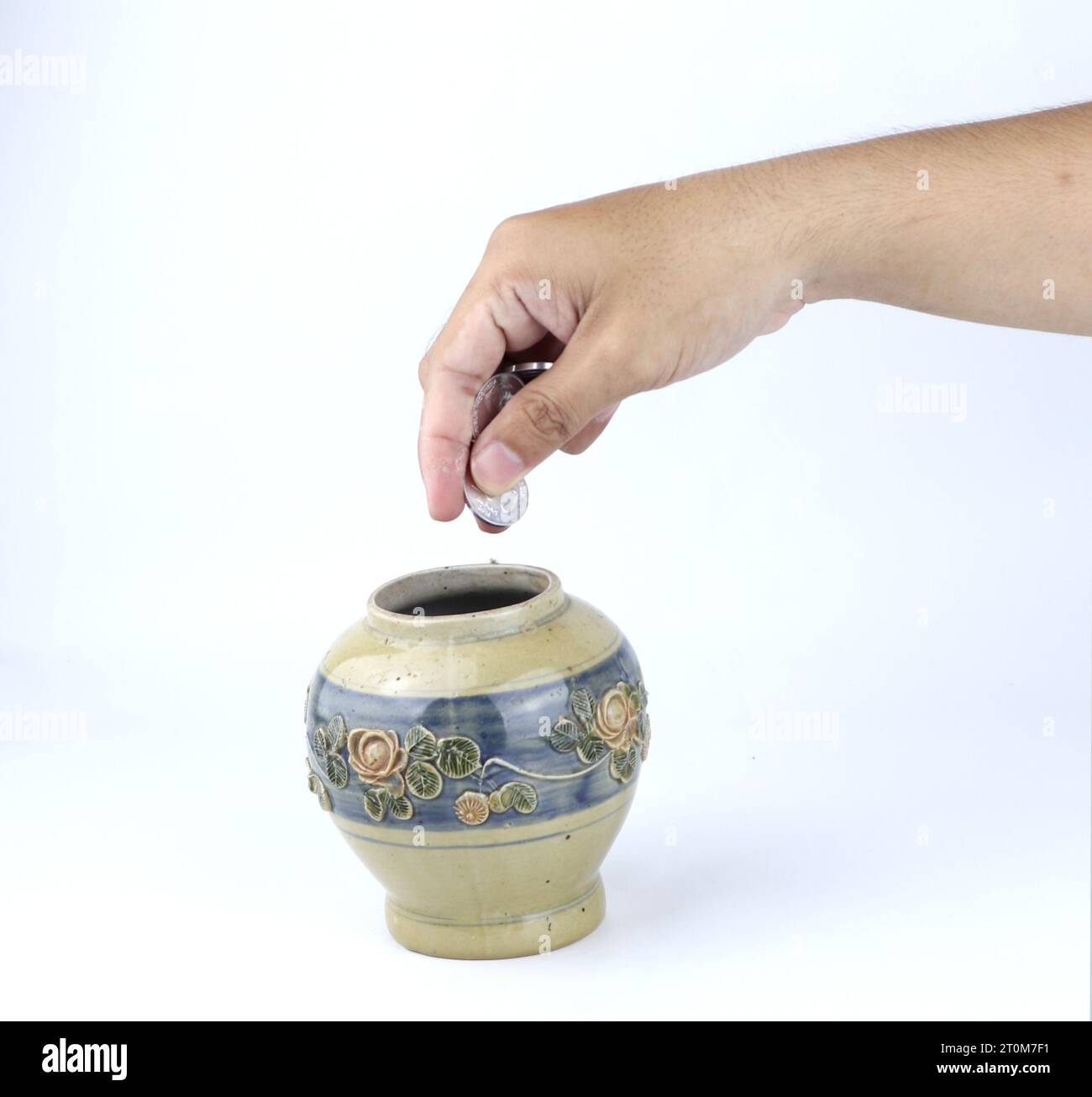 hand putting coins into a ceramic vase Stock Photo - Alamy