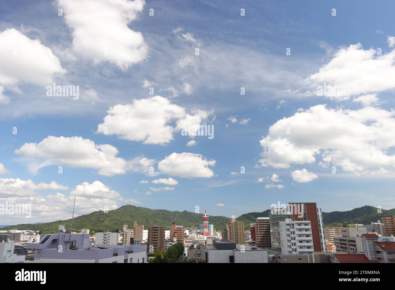 a landscape with buildings, mountains, sky, and clouds Stock Photo - Alamy