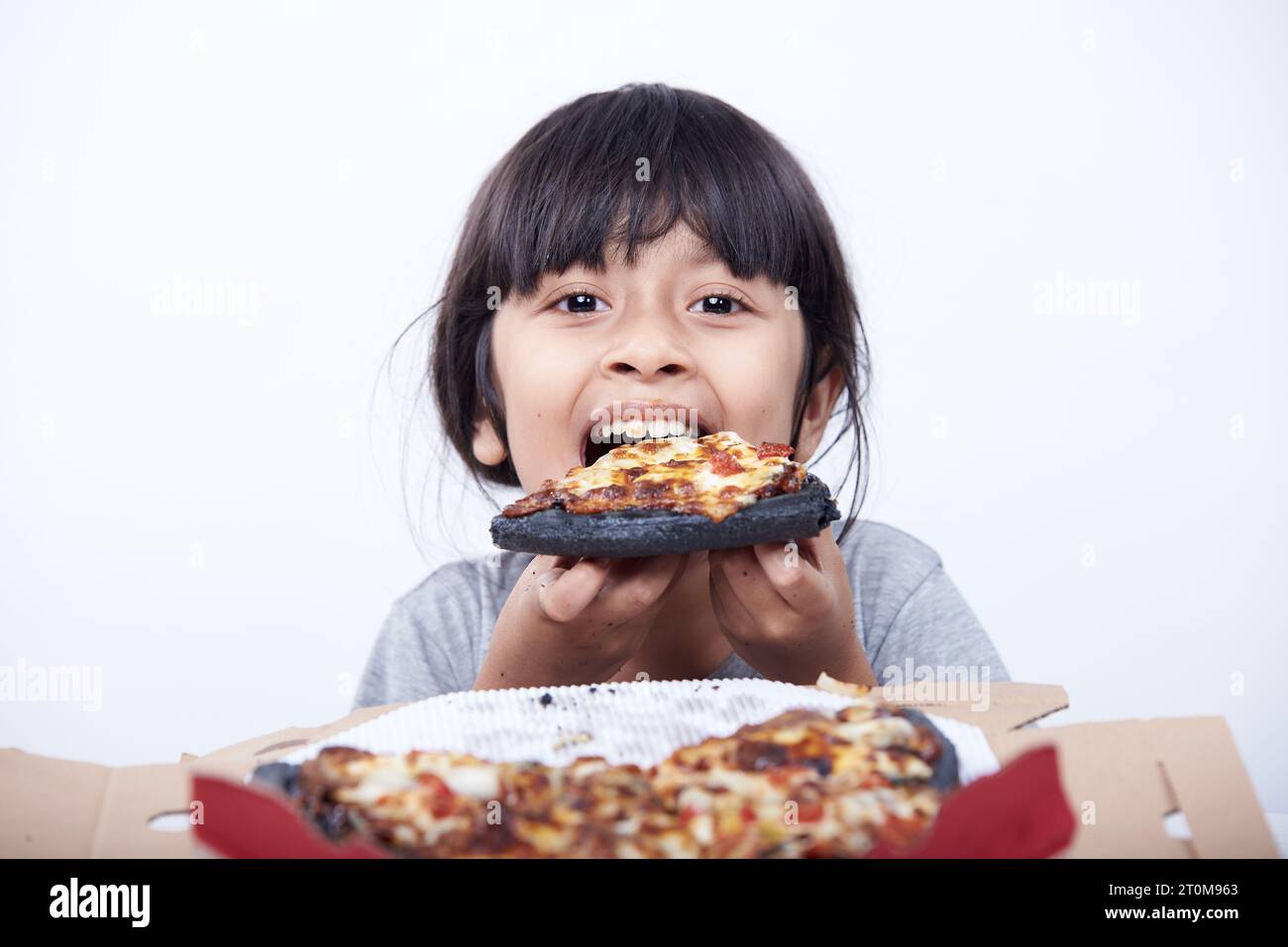 Little girl eating Delicious cheesy pizza for lunch Stock Photo - Alamy
