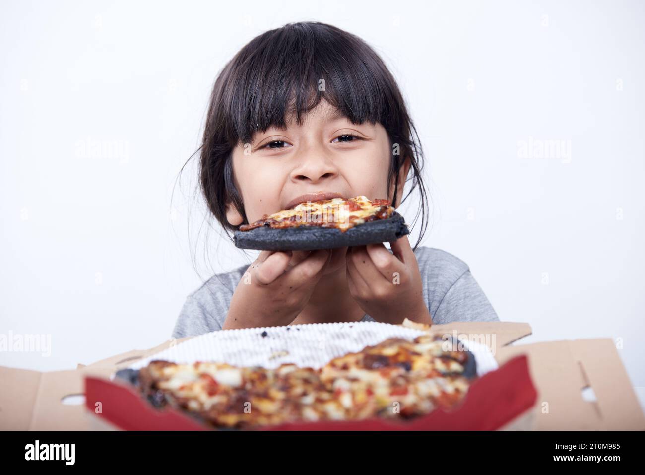 Little girl eating Delicious cheesy pizza for lunch Stock Photo - Alamy