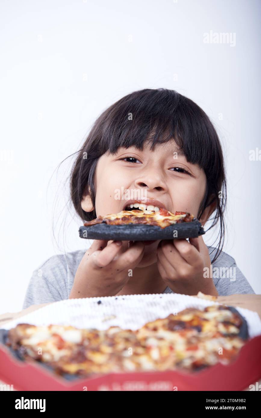 Little girl eating Delicious cheesy pizza for lunch Stock Photo - Alamy