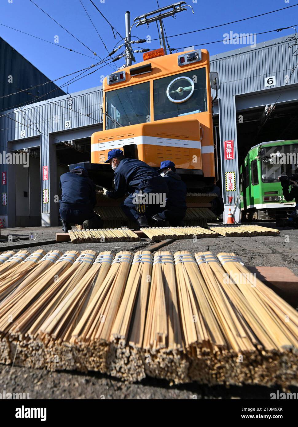 Workers prepare to move a sasara train, a snowplow train, in Sapporo ...
