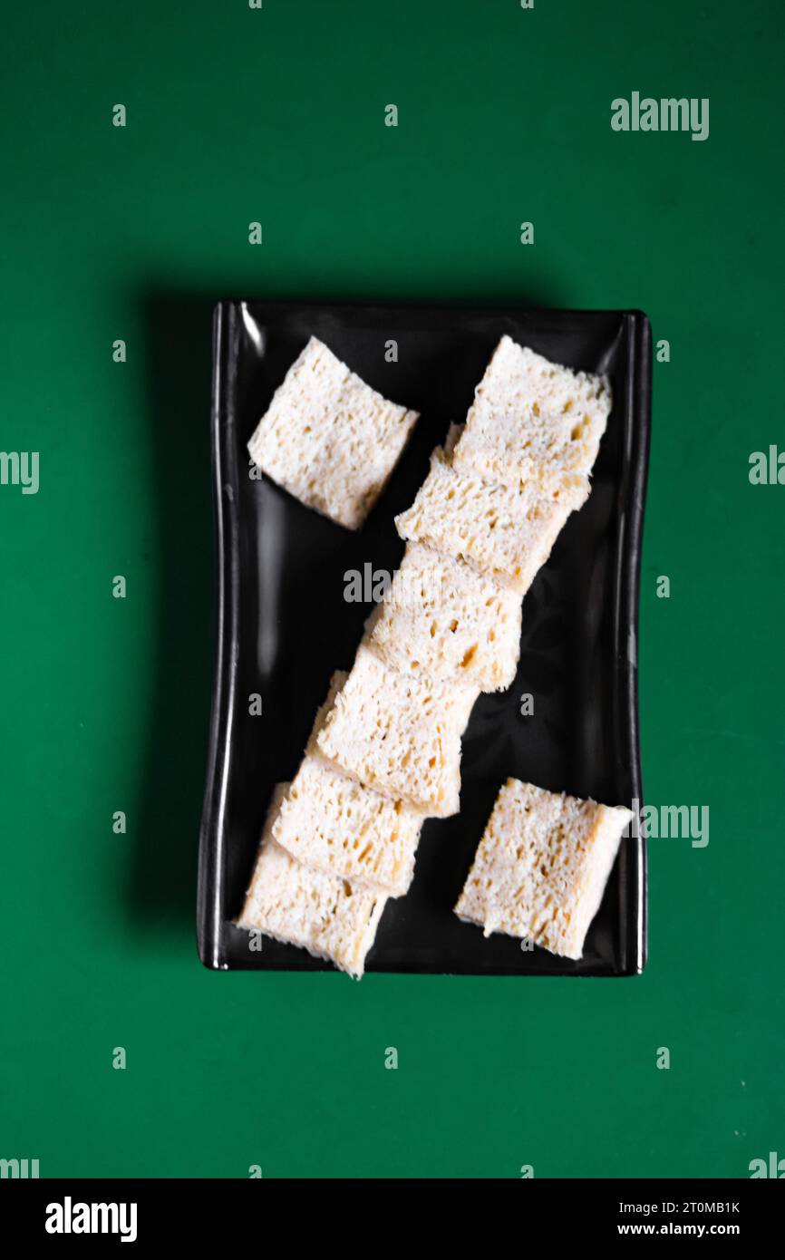 amazing cutted wheat protein gluten on a green background. Garnish ...