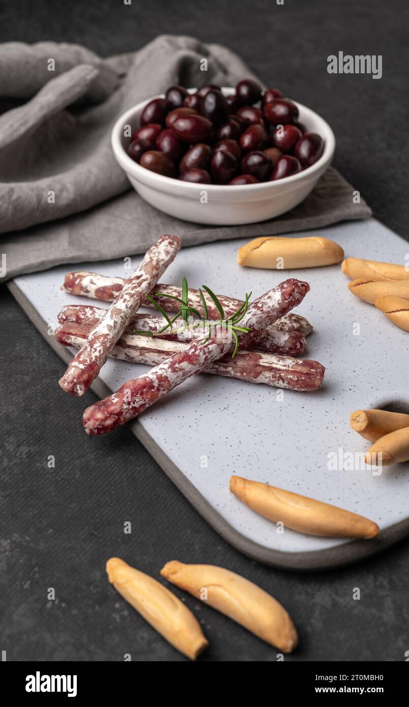 Spanish mini fuet, olives and picos Stock Photo - Alamy