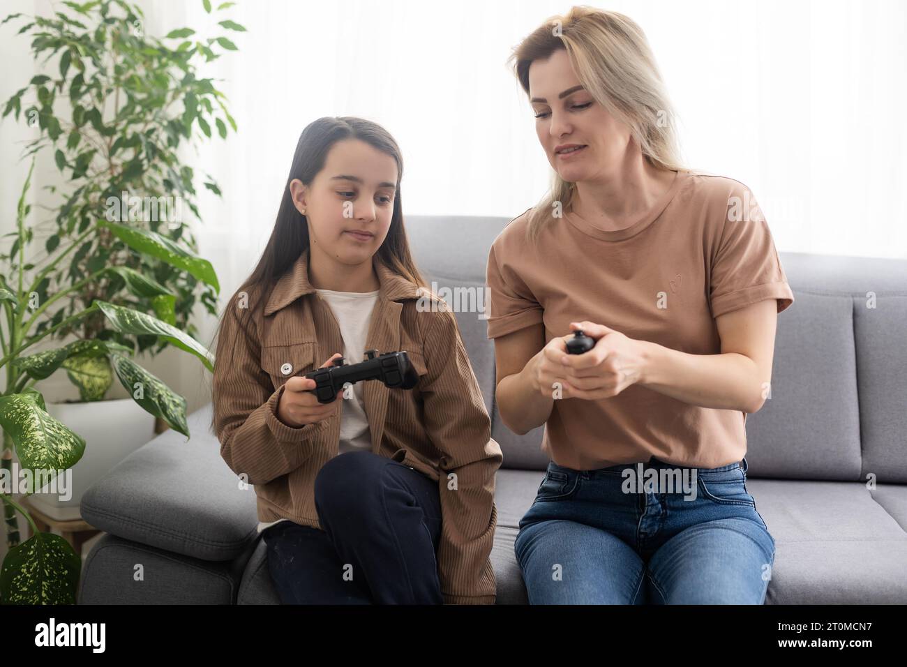Happy family together. Mother and her child girl playing video games ...