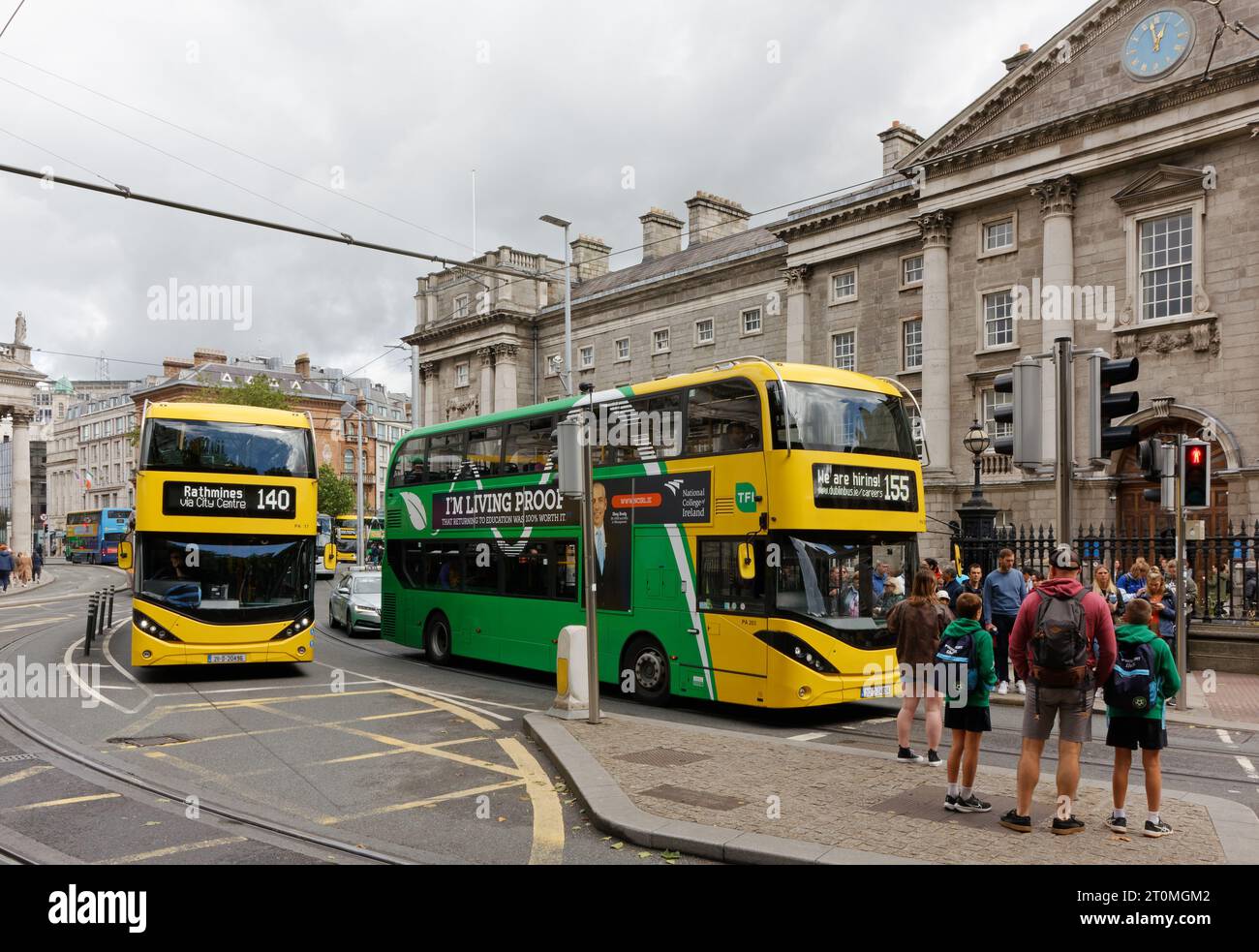 DUBLIN, Ireland - August 5, 2023: Two buses passing in front of Trinity ...