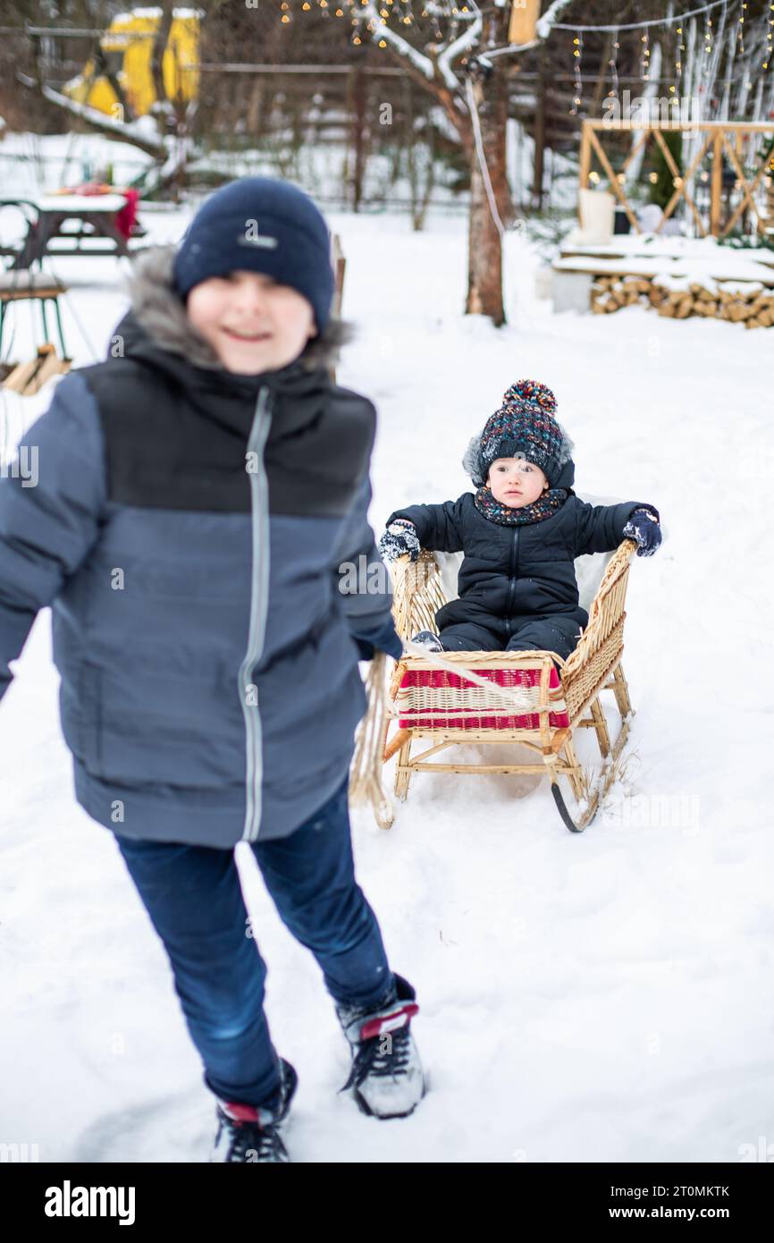 Boy pulling his friend on a sledge Stock Photo - Alamy