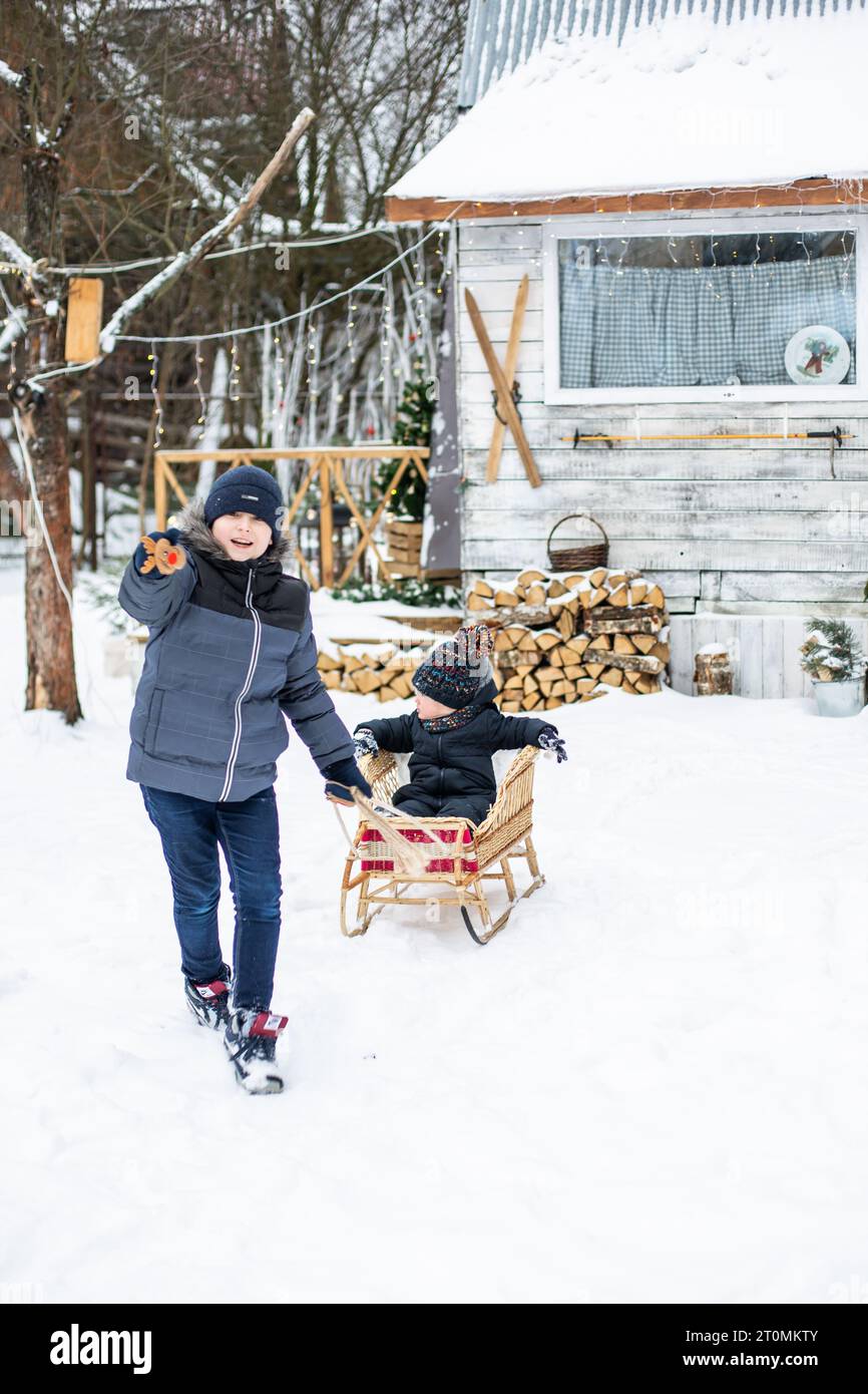 Boy pulling his friend on a sledge Stock Photo - Alamy