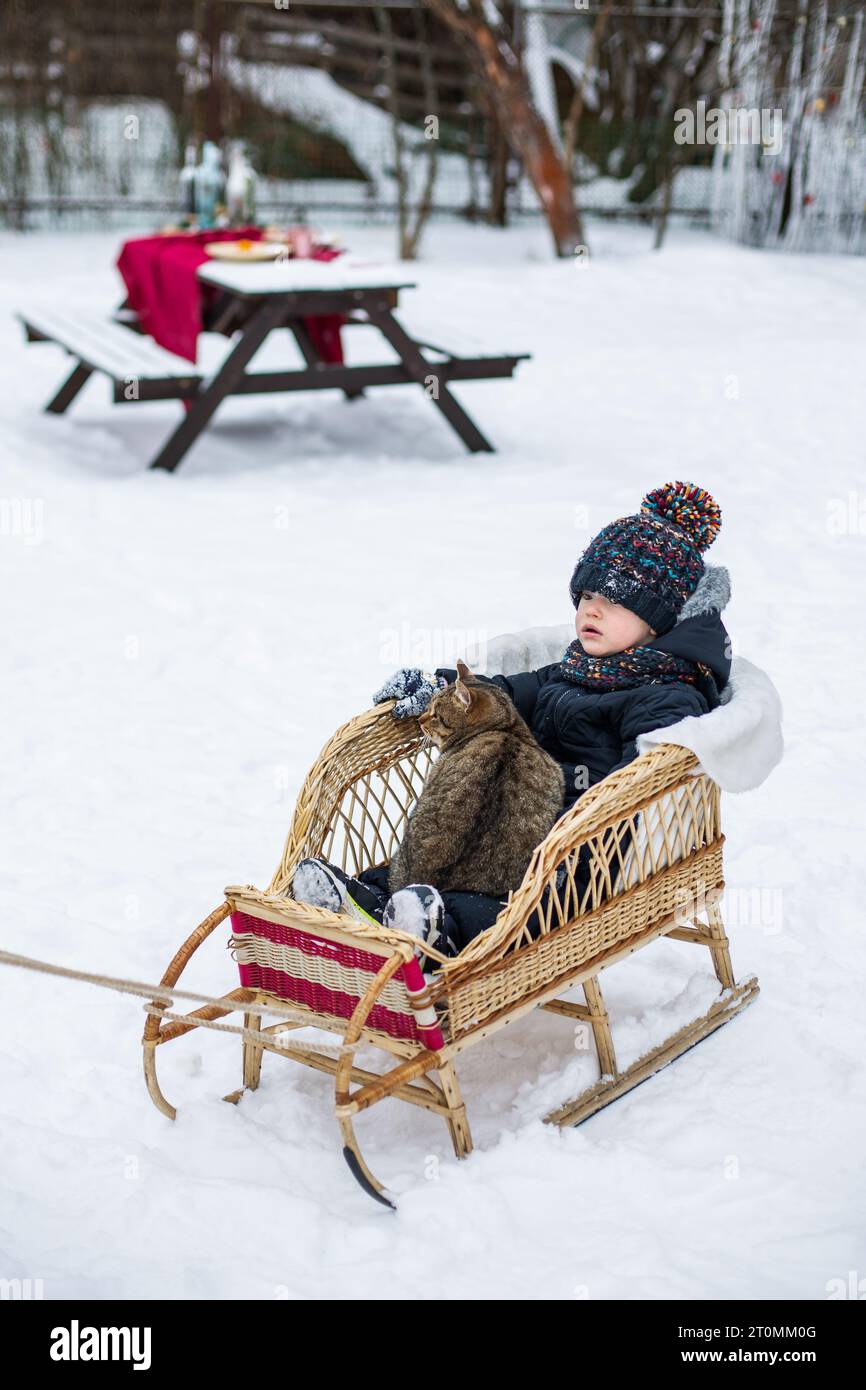 Boy pulling his friend on a sledge Stock Photo - Alamy