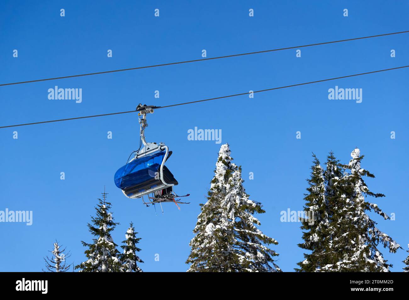 Chairlift of ropeway against blue sky. Cable car transports winter ski ... Chairlift of ropeway against blue sky. Cable car transports winter ski ...