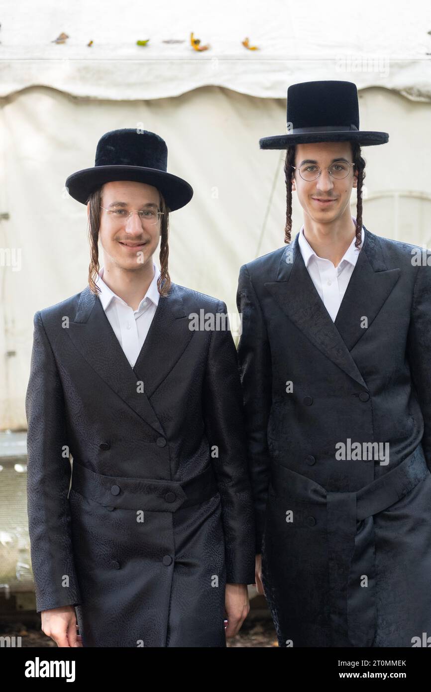 A posed portrait of orthodox Jewish brothers each dressed in black and ...