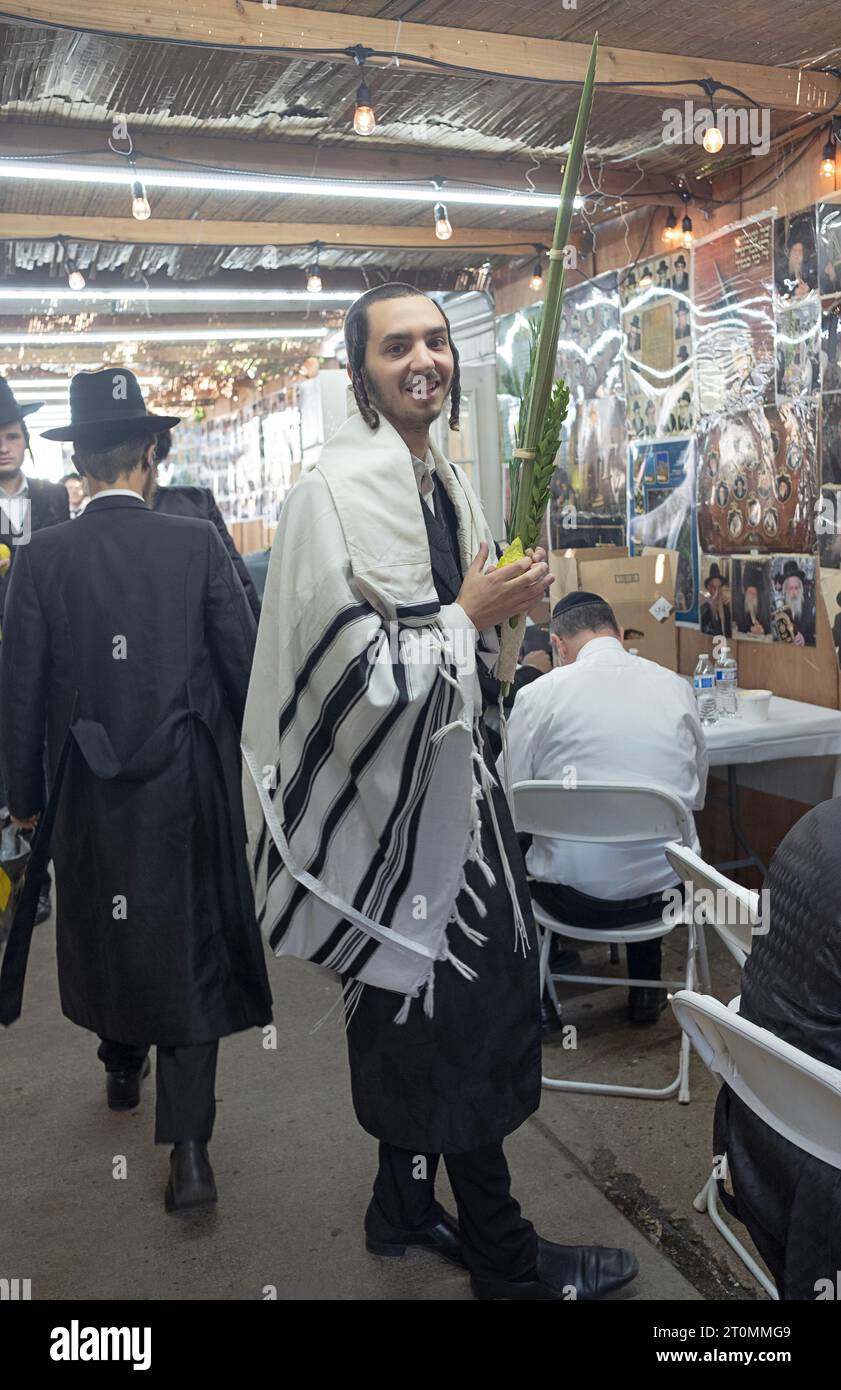 After blessing the 4 Sukkos species in a Sukkah, an orthodox Jewish man ...
