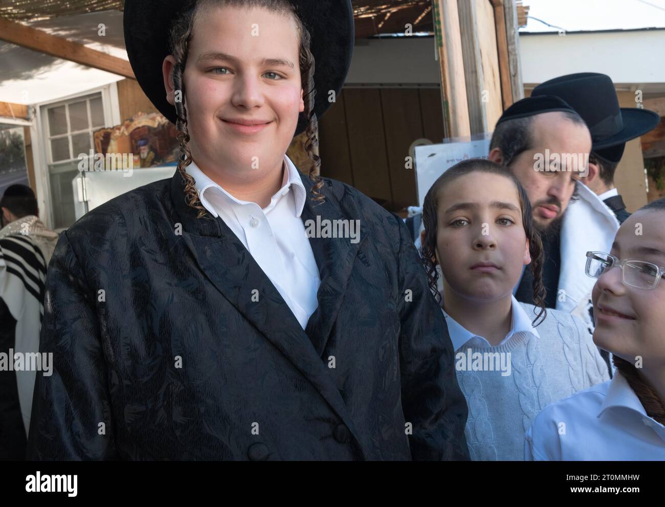 A group of orthodox Jewish men and boys inside a Sukkah during Sukkos ...