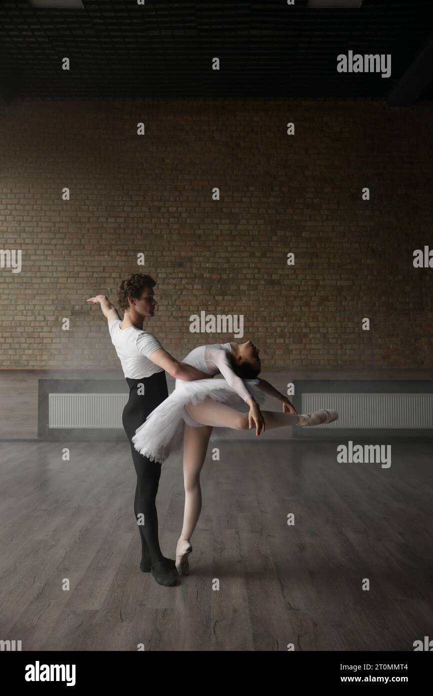 Woman and man ballet dancers in dynamic action against studio ...