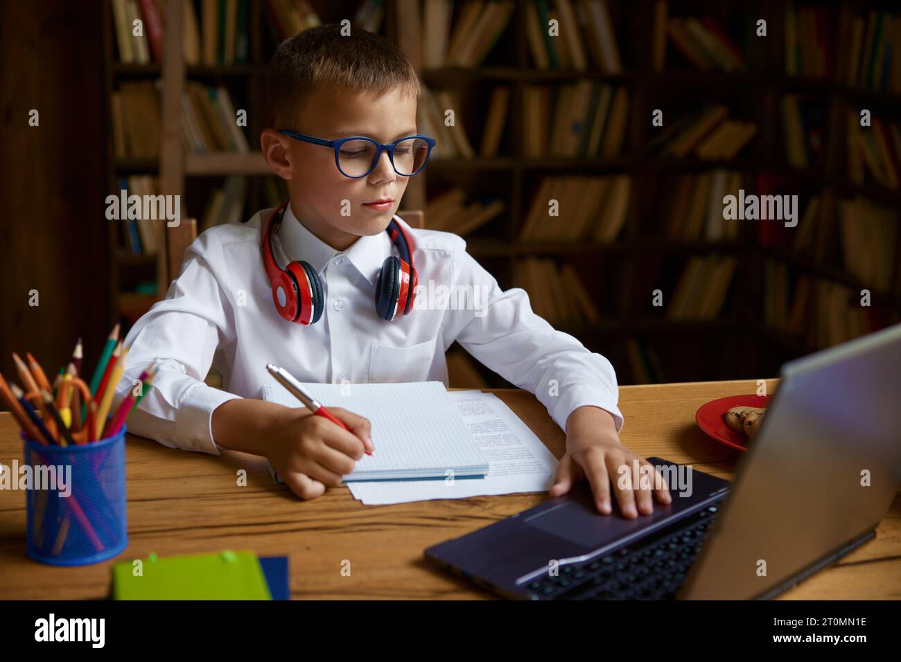 Little boy child studying at home table sitting front of computer ...