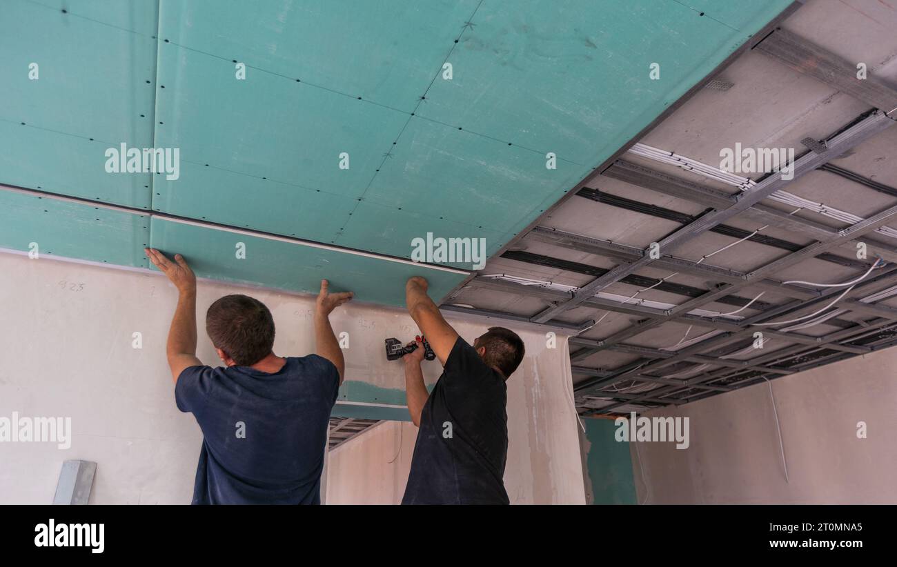 Construction worker ceiling work installation Stock Photo - Alamy