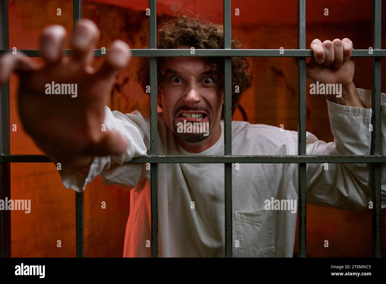 Angry crazy man prisoner and psychiatric hospital patient in cage Stock ...